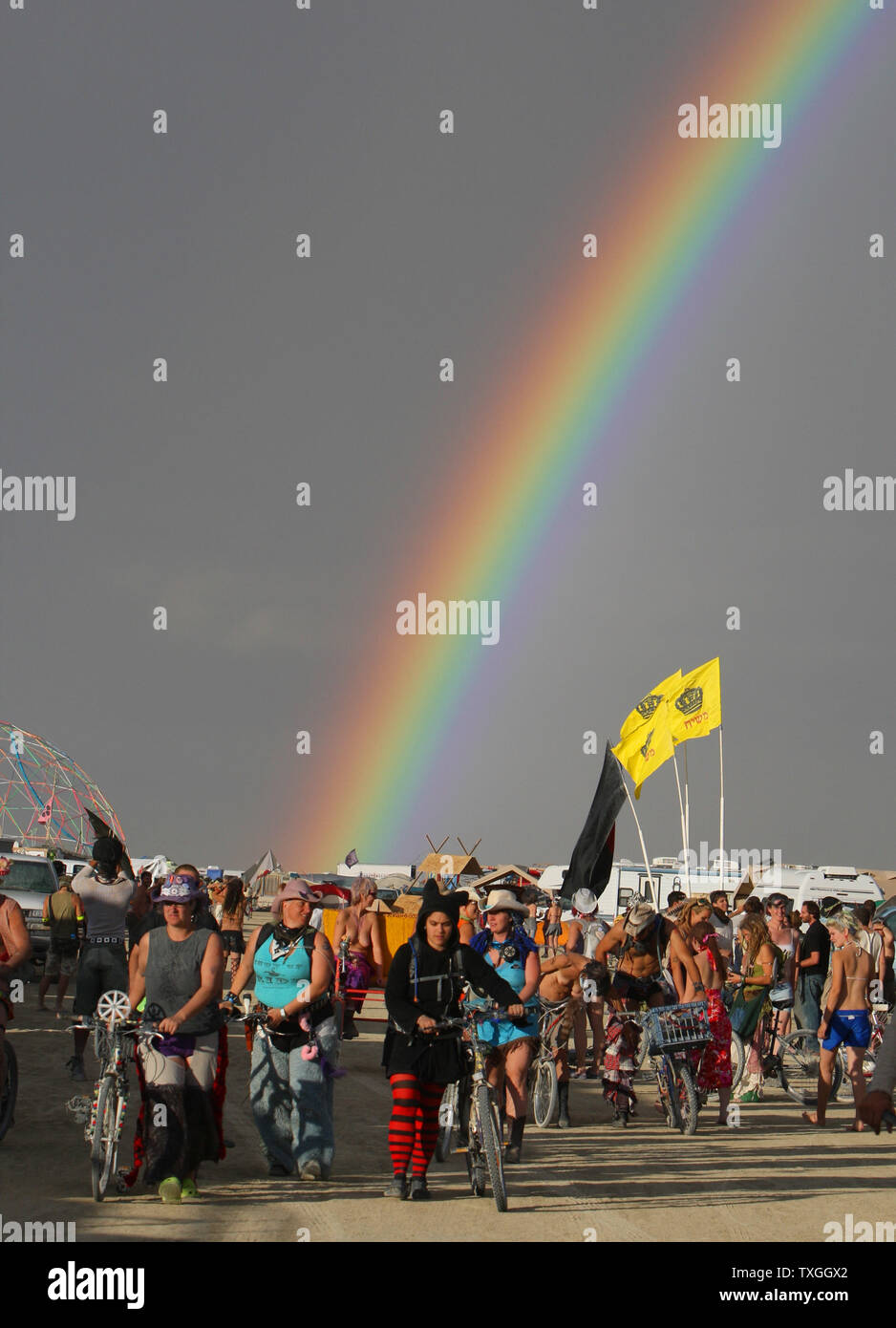 Residents make their way through camp under a rainbow at Burning Man in ...