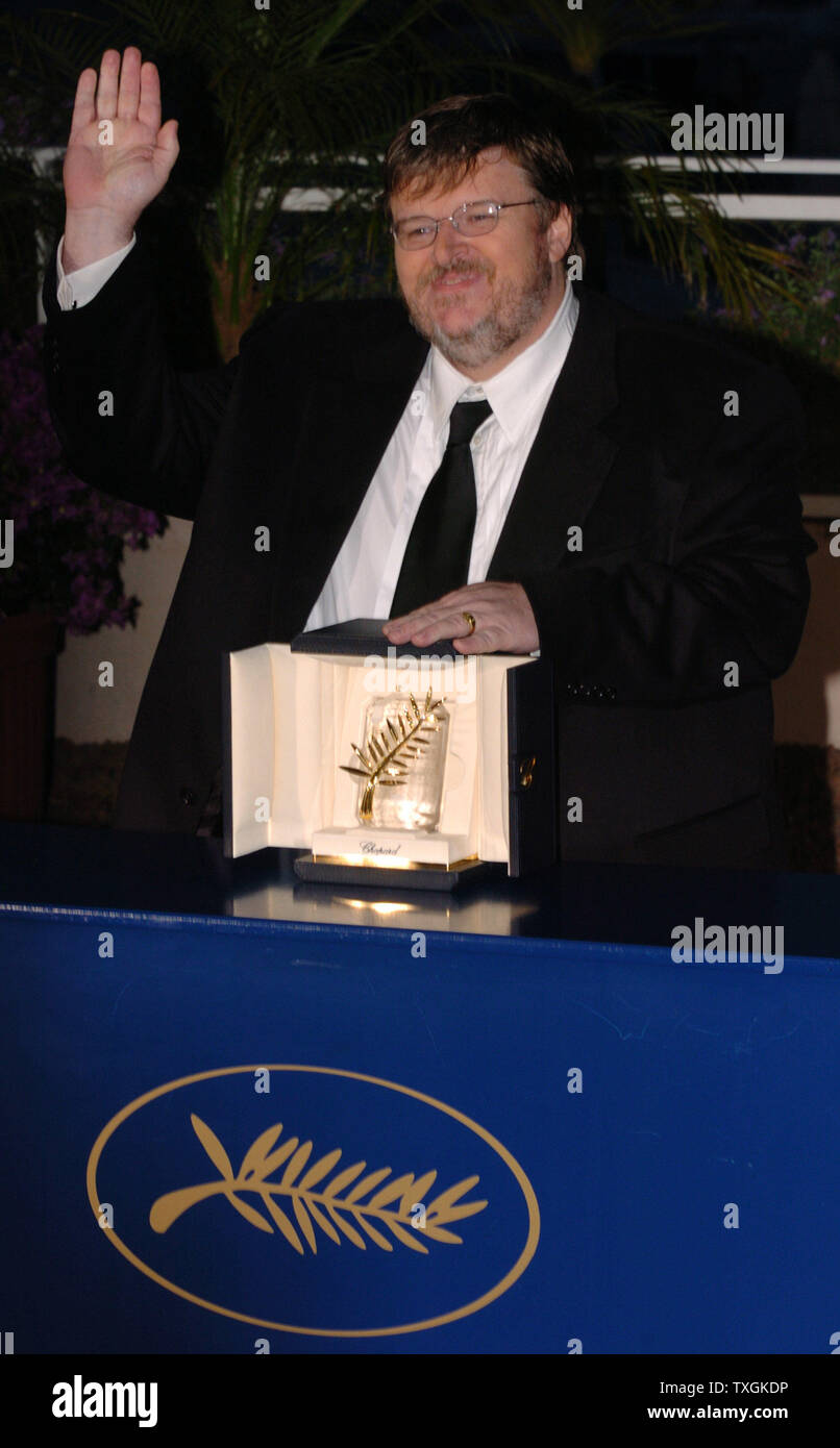 Director Michael Moore acknowledges the cheers of photographers at a ...