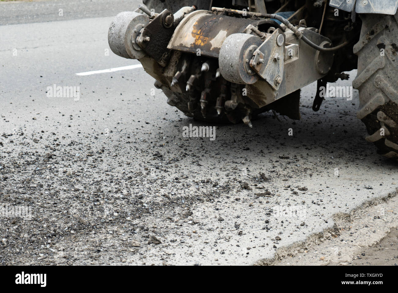 Road milling machine cuts the old asphalt. Road repair. Destruction of ...