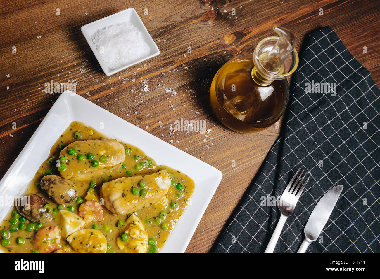 healthy traditional spanish hake dish with green seafood sauce with ...