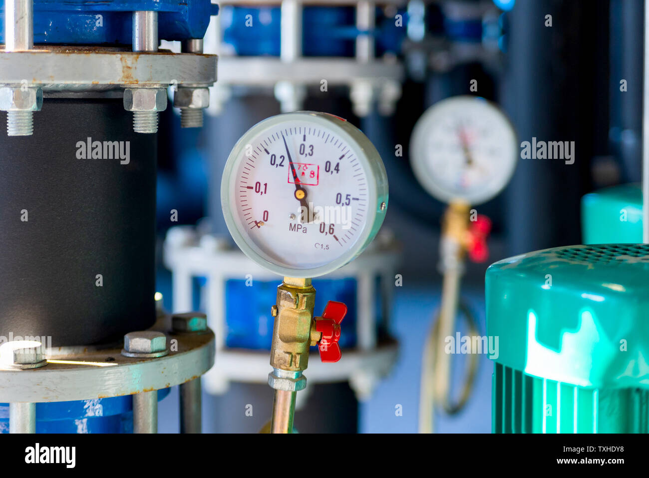 Closeup of manometer, measuring gas pressure. Pipes and valves at industrial plant. Pressure ...