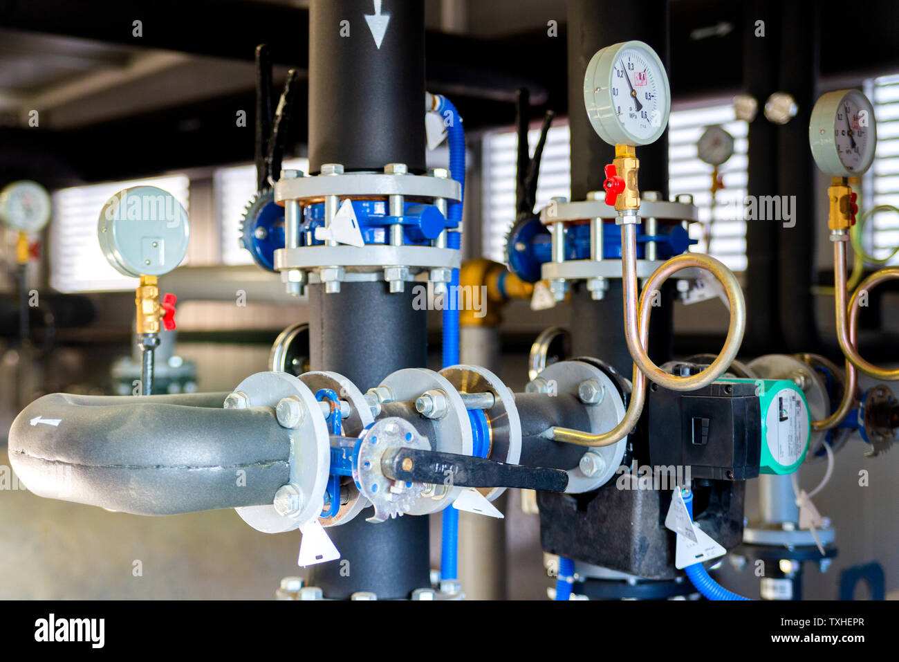 Closeup of manometer, measuring gas pressure. Pipes and valves at industrial plant. Pressure ...