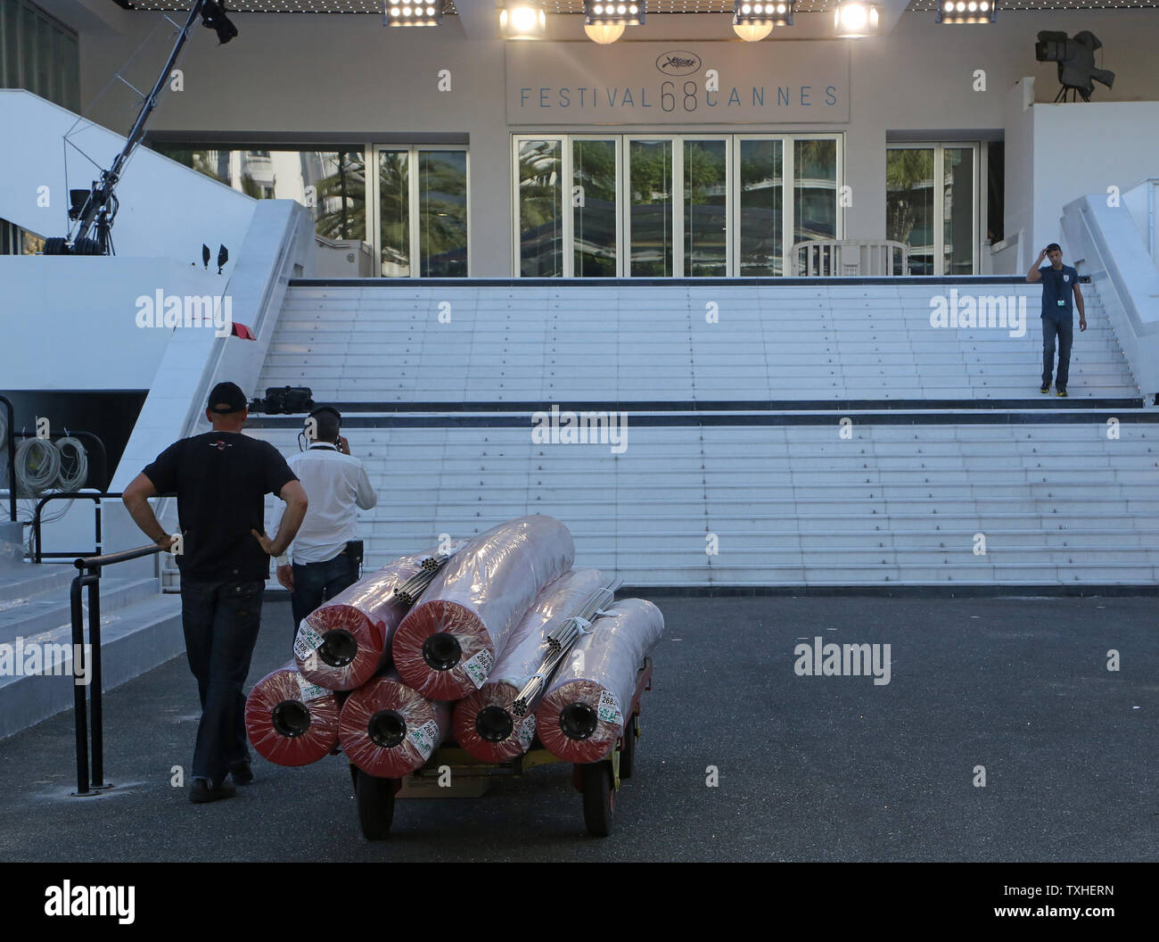 Workers prepare to lay the red carpet on the steps of the Palais des ...