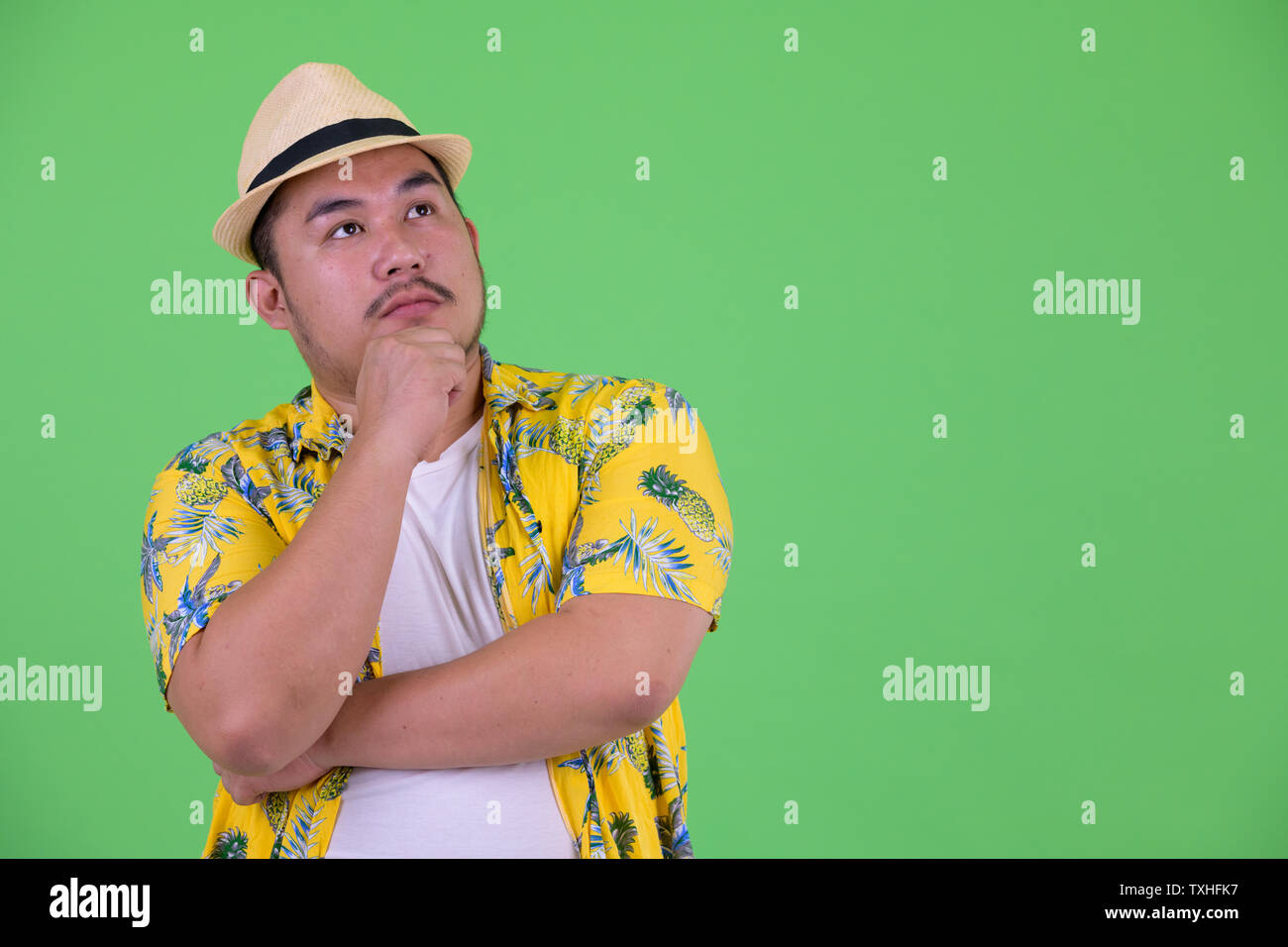 Young overweight Asian tourist man thinking and looking up Stock Photo ...