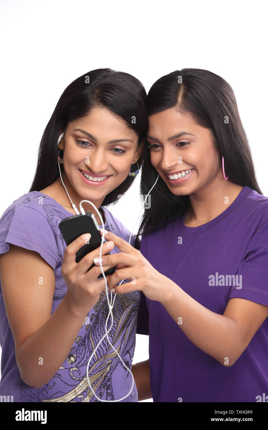 Two friends listening to music on an mp3 player Stock Photo - Alamy