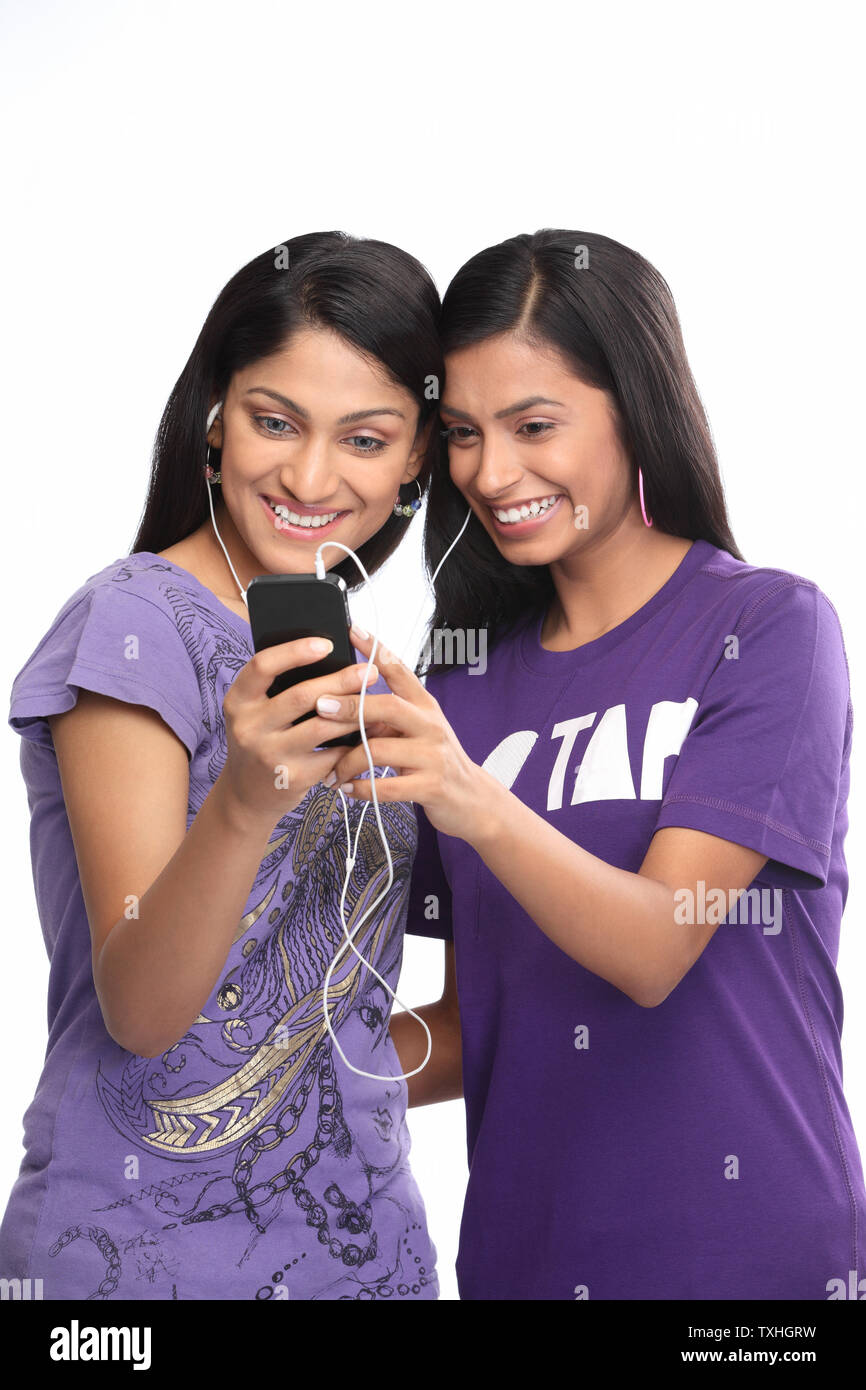Two friends listening to music on an mp3 player Stock Photo - Alamy