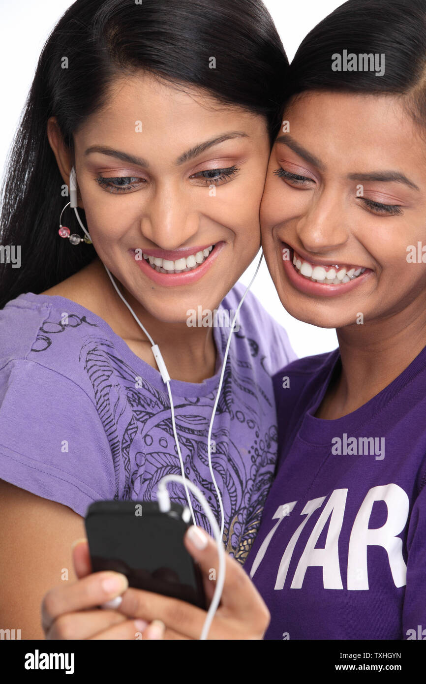 Two friends listening to music on an mp3 player Stock Photo - Alamy
