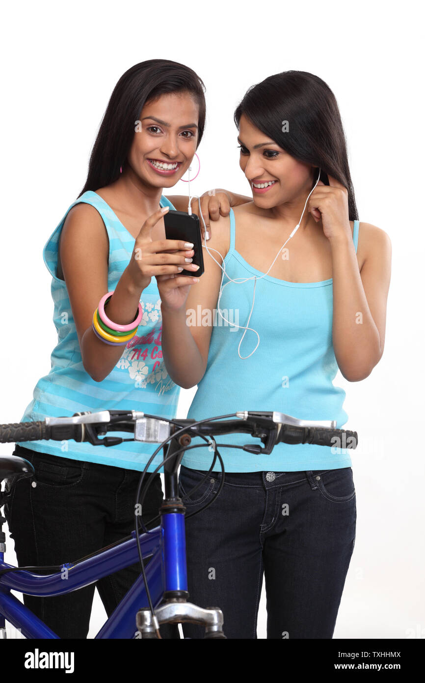 Two friends listening to music on an mp3 player Stock Photo - Alamy