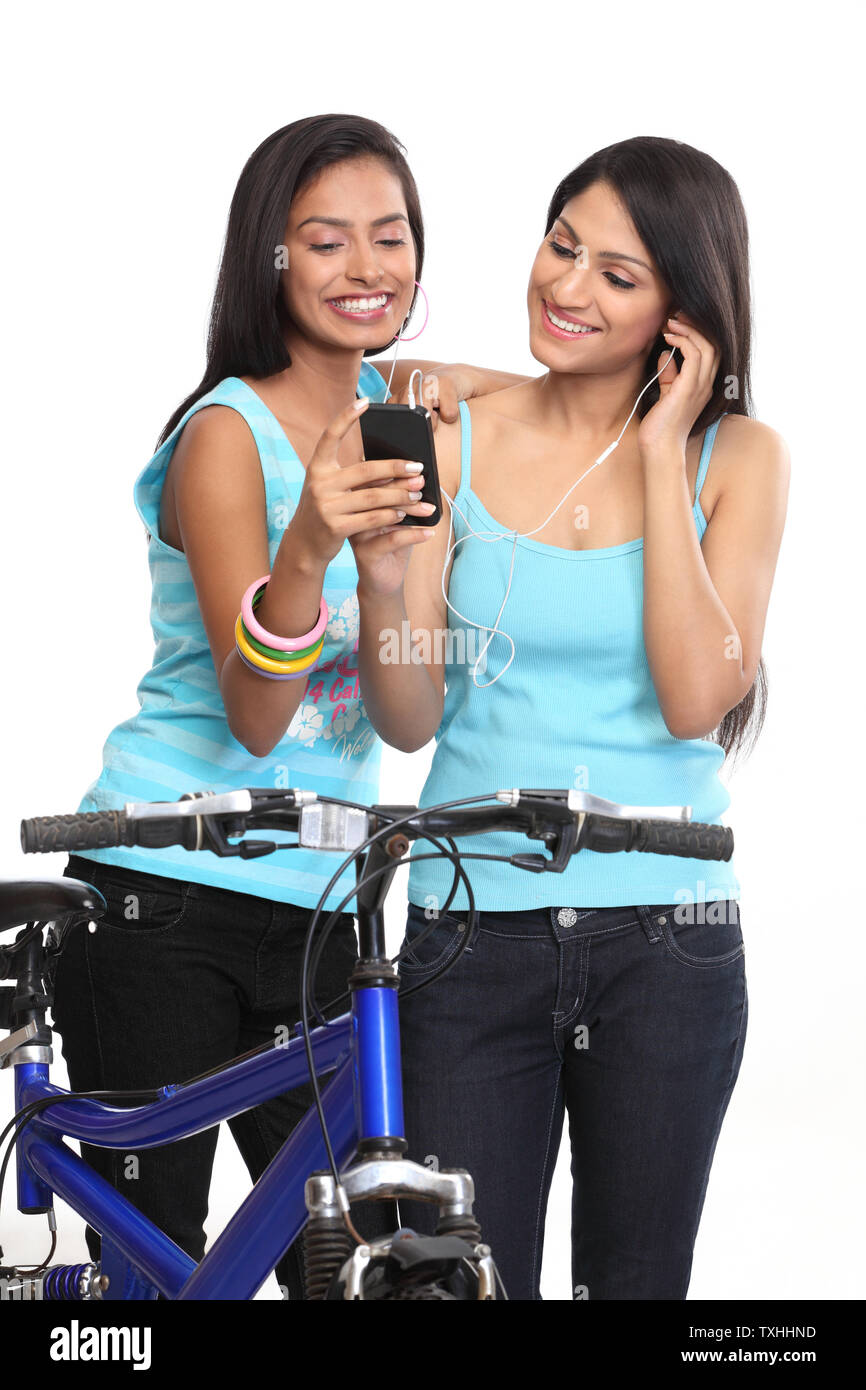 Two friends listening to music on an mp3 player Stock Photo - Alamy