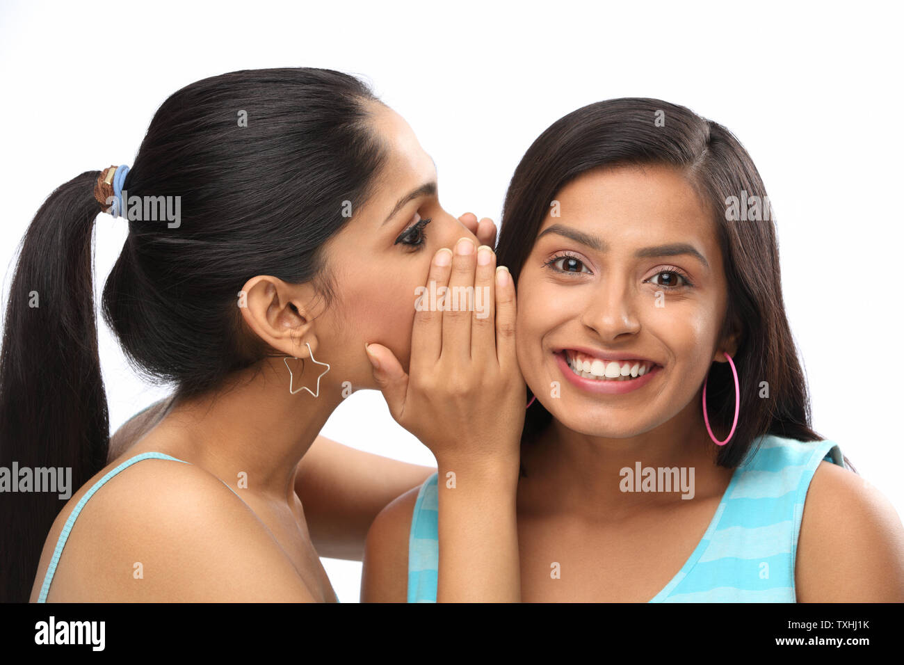 Teenage girl whispering a secret to her friend Stock Photo - Alamy