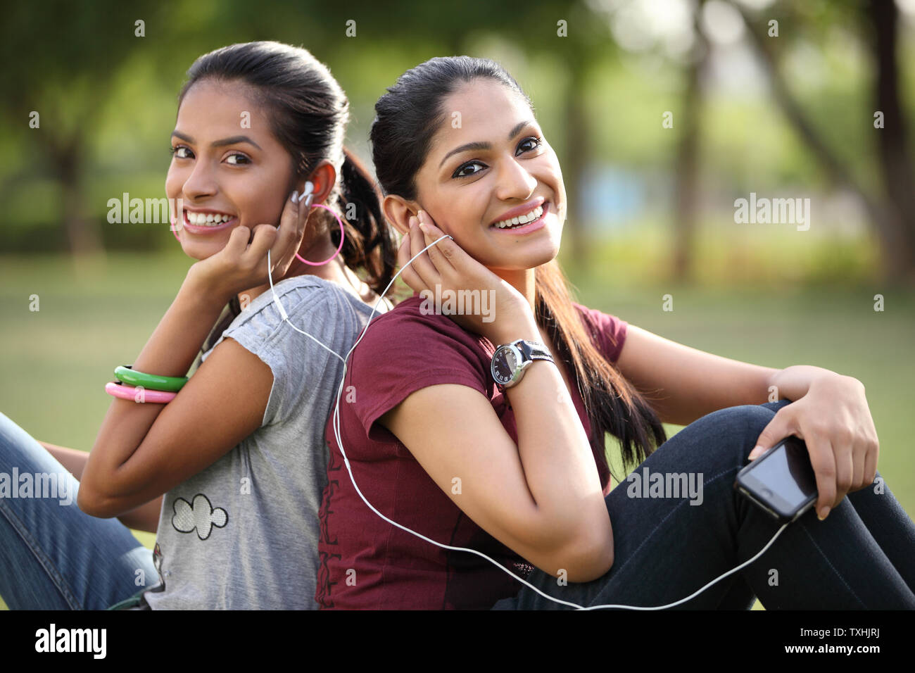 Two friends listening to music on an mp3 player Stock Photo - Alamy