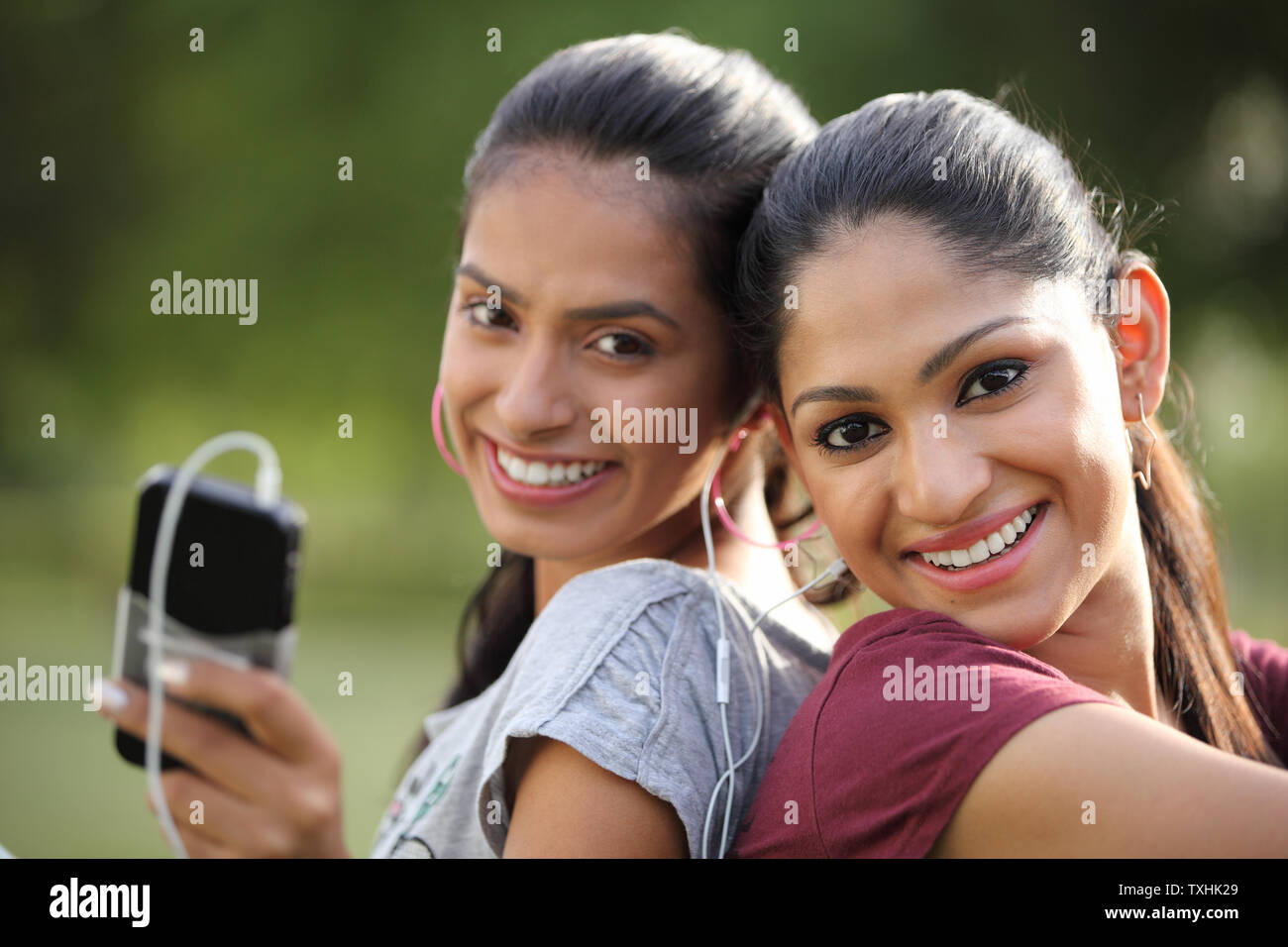 Two friends listening to music on an mp3 player Stock Photo - Alamy