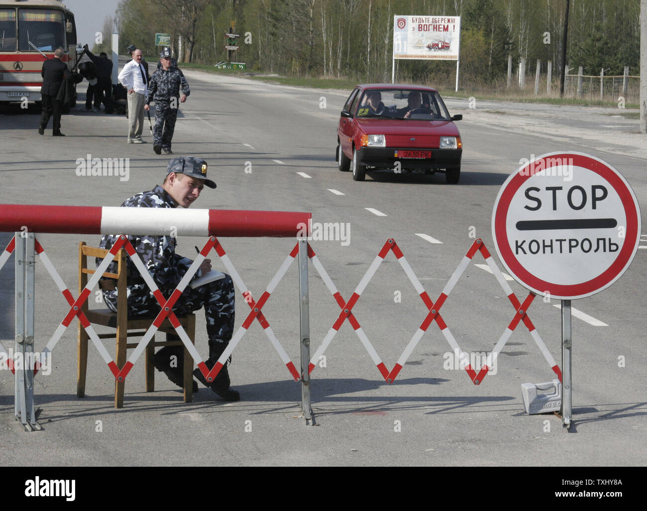 A road police officer watches cars going to the Chernobyl nuclear plant ...