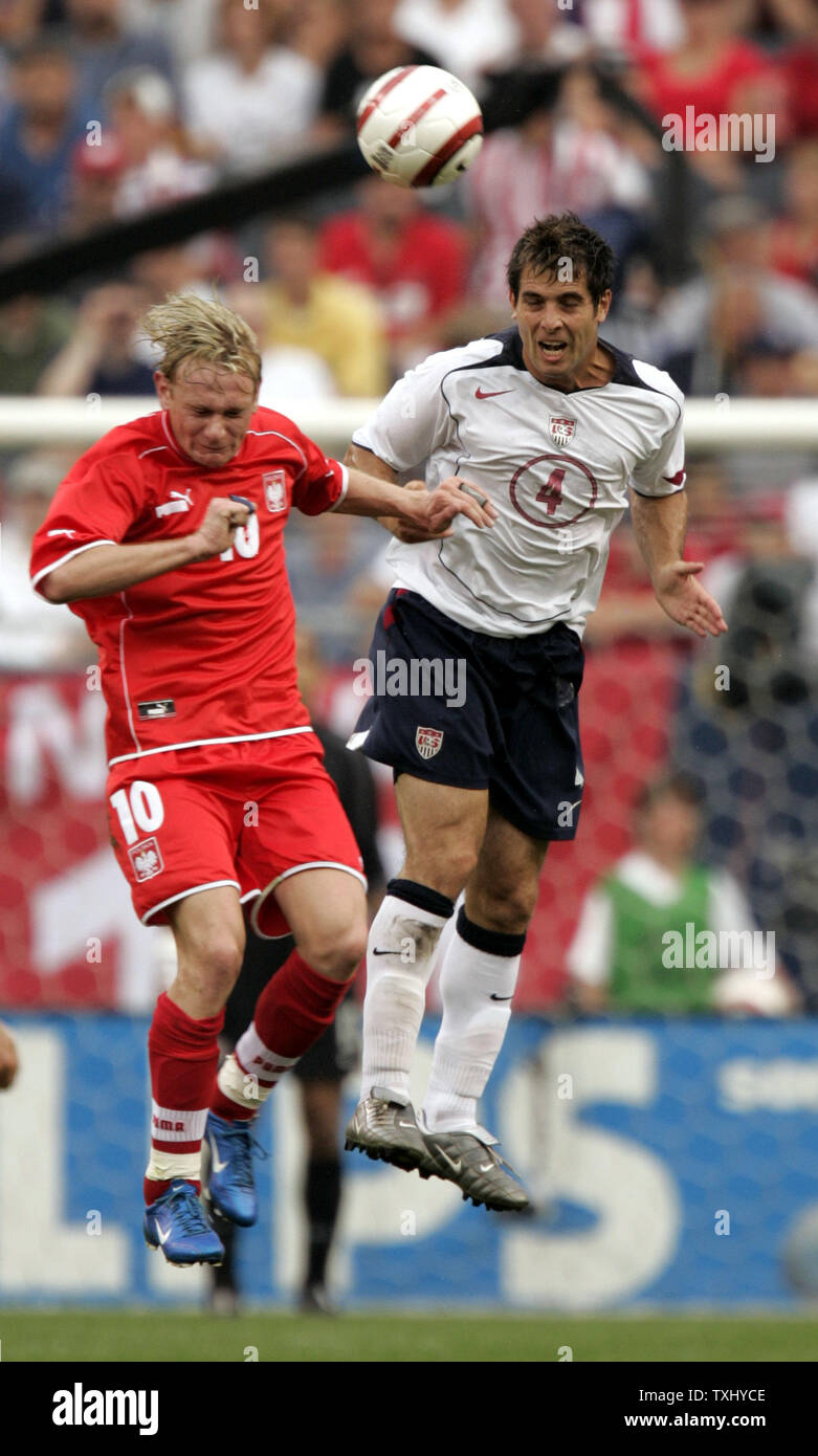 USA's Carlos Bocanegra, (4), and Poland's Sebastian Mila, (10), go up ...