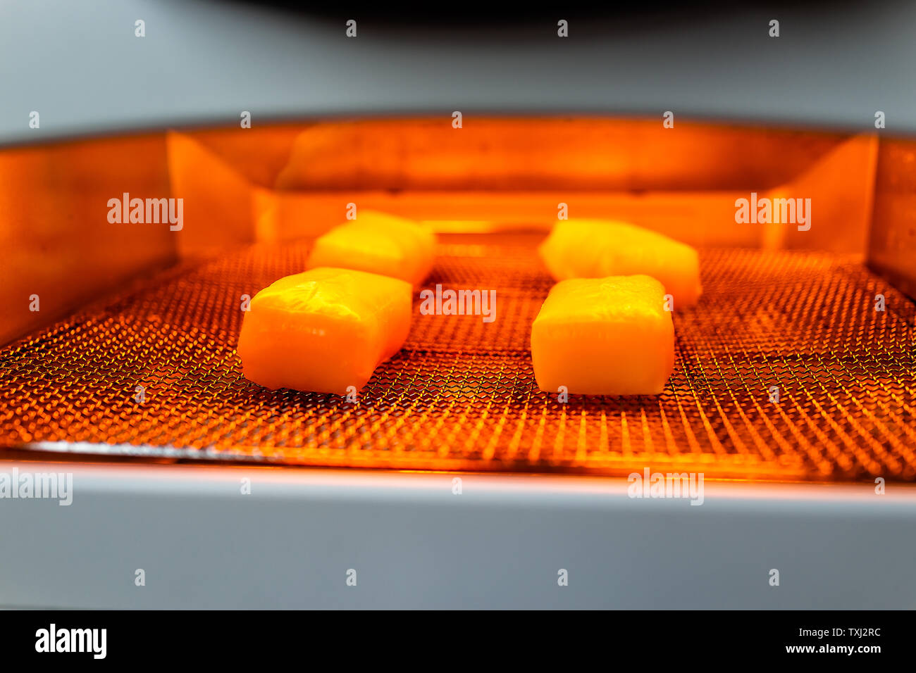 Mochi rice cake squares being baked in toaster oven in traditional ...
