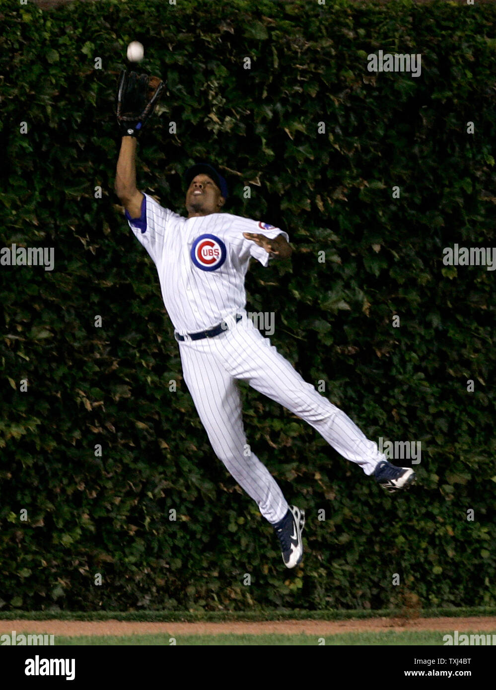 Chicago Cubs center fielder Jacque Jones jumps up to catch Cincinnati ...