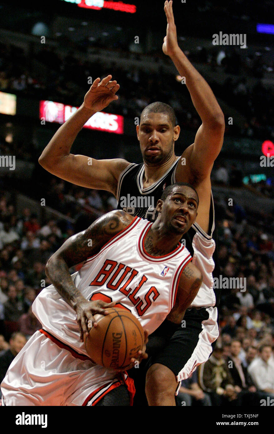 Chicago Bulls guard Larry Hughes (L) drives past San Antonio Spurs ...