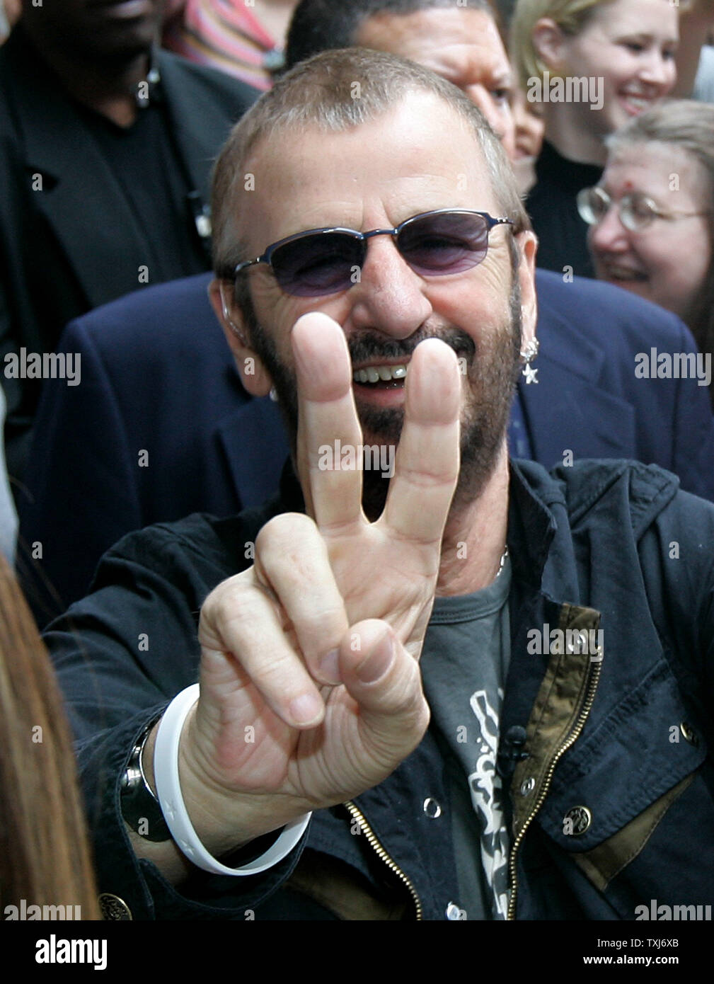 Former Beatle Ringo Starr greets fans with the peace sign in ...