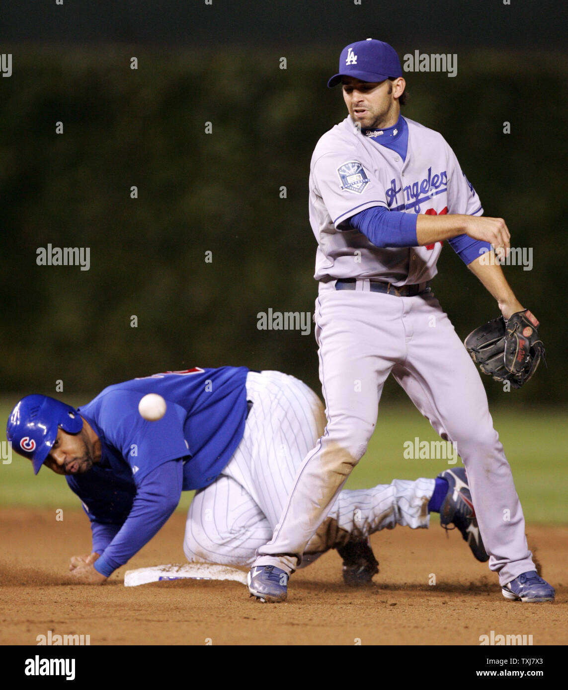 Chicago Cubs base runner Derrek Lee, left, hits the ground after Los ...