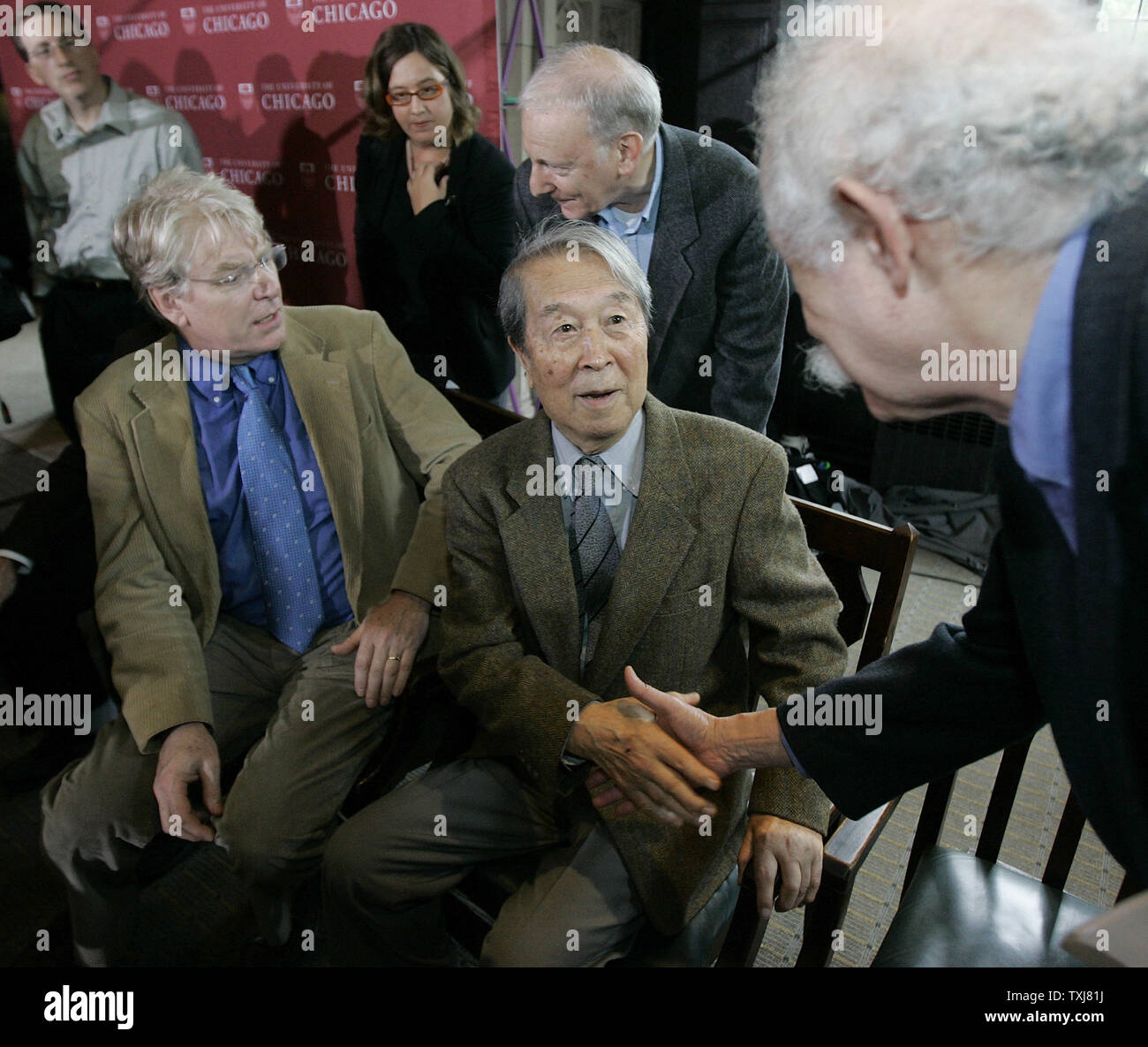 University of Chicago professor Yoichiro Nambu (C) shakes hands with ...