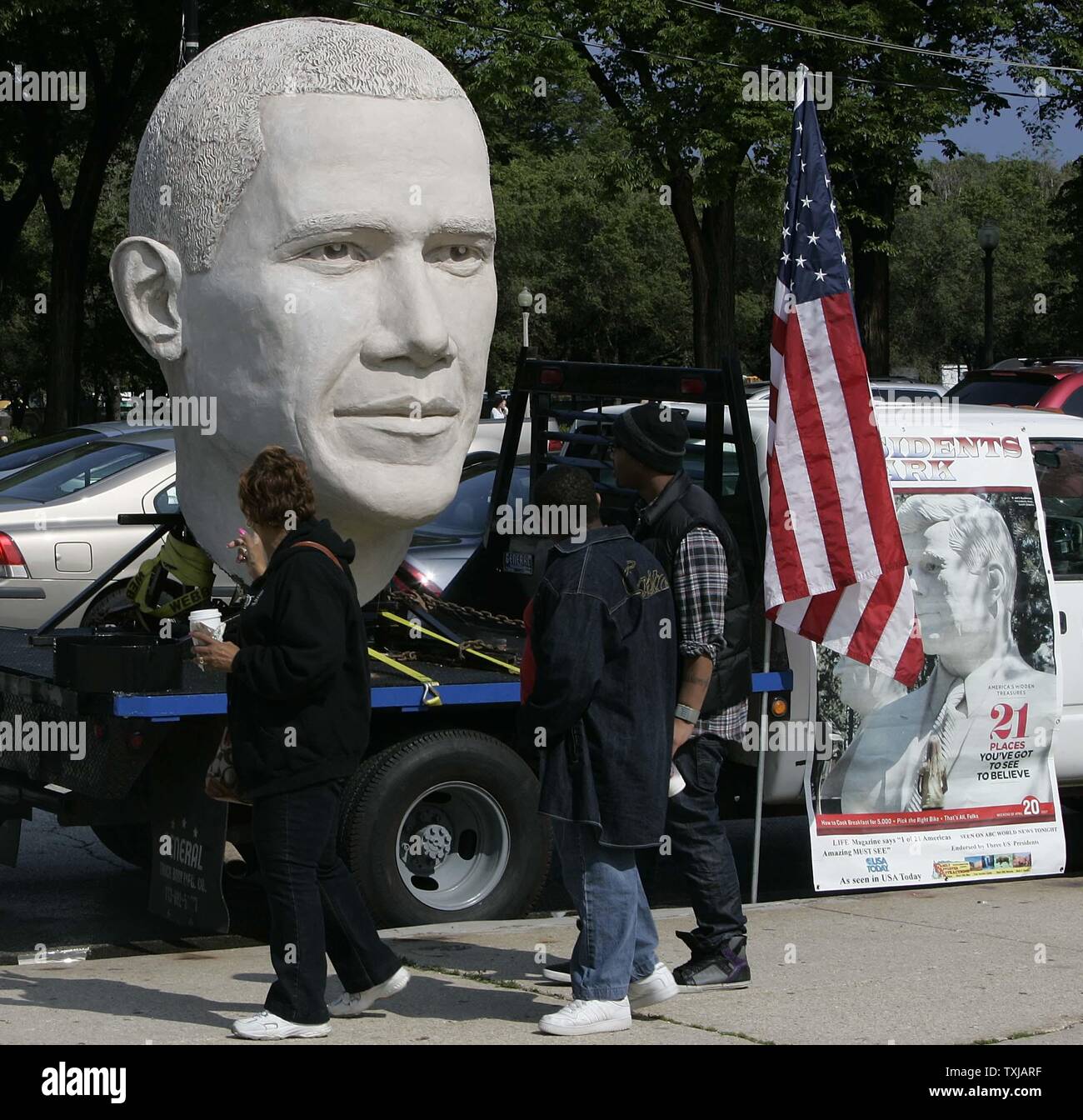 People pose with a traveling sculpture of U.S. President Barack Obama ...