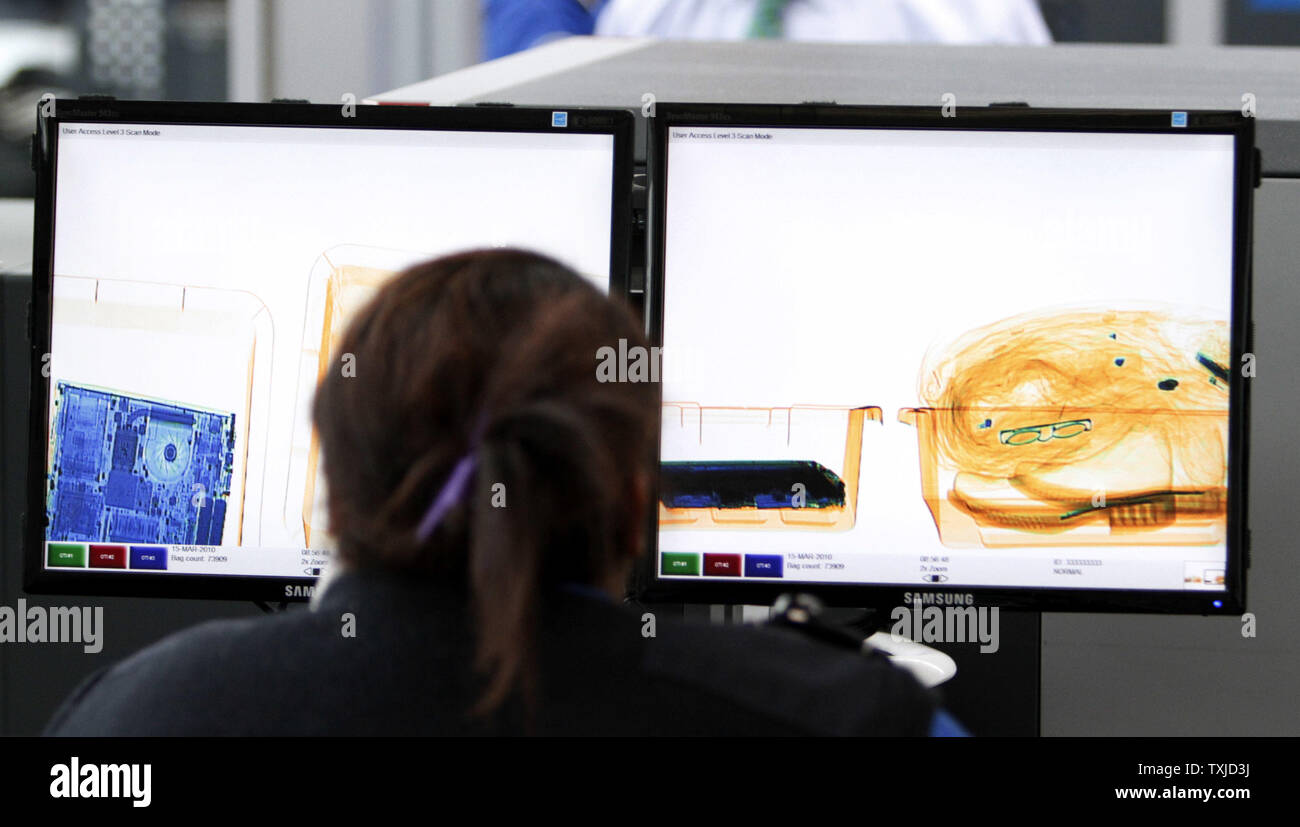 A TSA screener looks at x-ray images at a security checkpoint at O'Hare ...