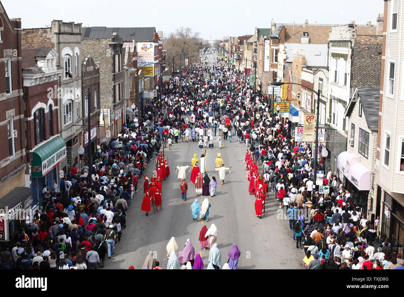 People walk along with the Via Crucis or 'Way of the Cross' performance ...