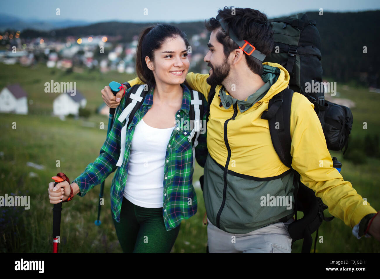 Backpackers couple hiking during fall with sticks Stock Photo - Alamy