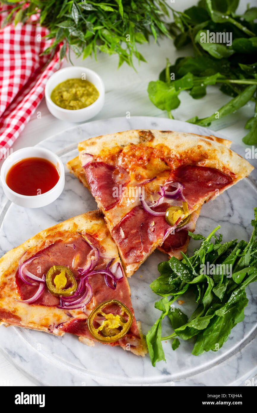 Smoked Ribs pizza with arugula and parmesan cheese on wood table ...