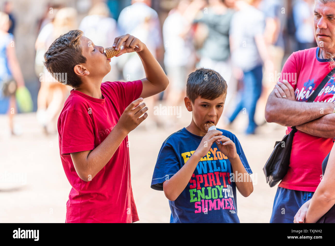 San Gimignano, Italy - August 27, 2018: Young children eating ice cream ...