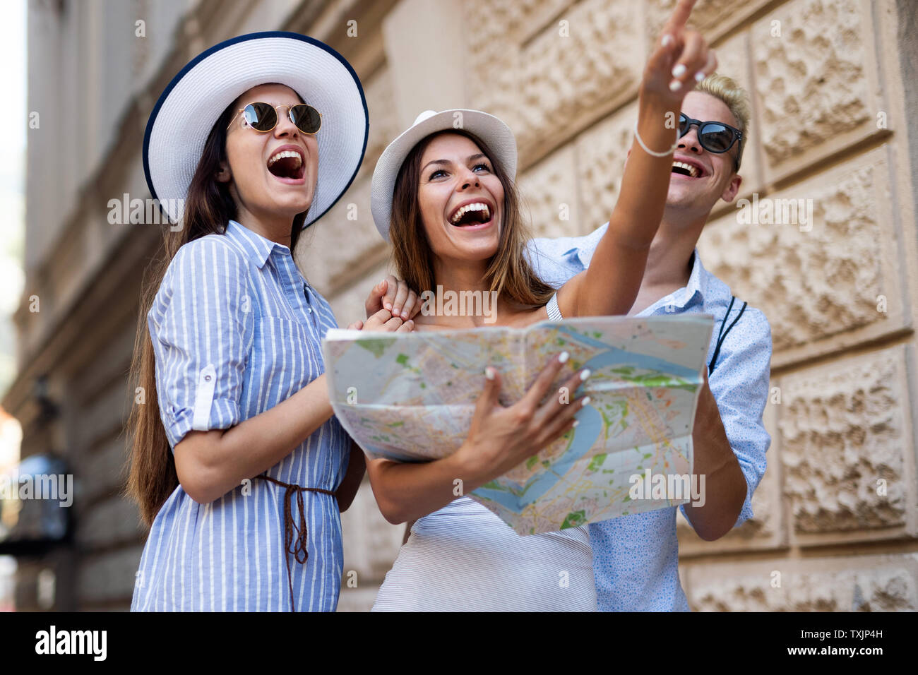 Happy group of tourists traveling and sightseeing together at summer ...