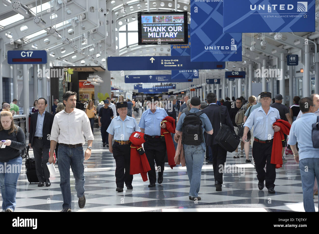 Travelers walk through United's Terminal 1 at O'Hare International ...