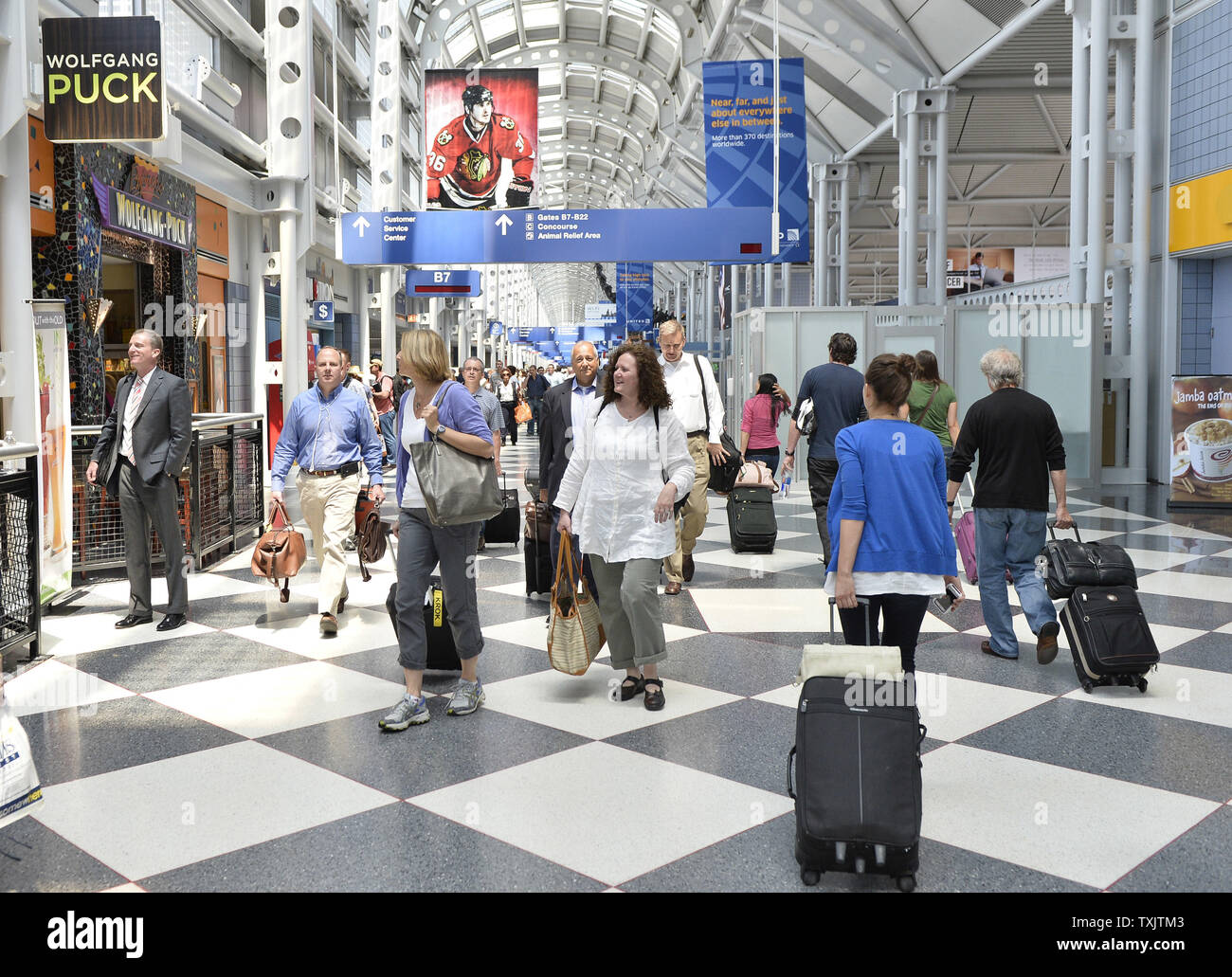 Travelers walk through United's Terminal 1 at O'Hare International ...
