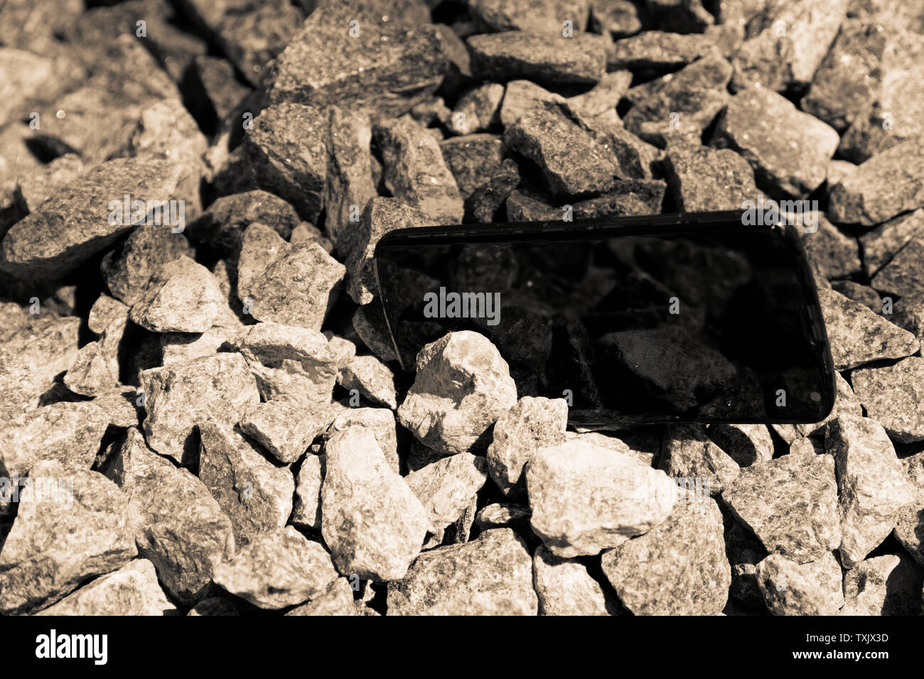 Broken cellphone abandoned and lost among the gravel Stock Photo - Alamy
