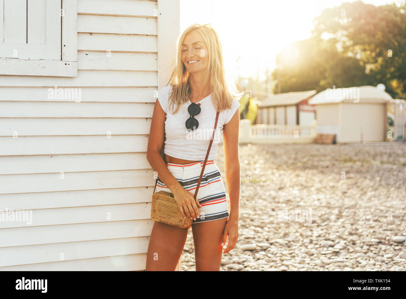 Woman backlit in the sun, summer beach look, relaxed relaxed posture ...