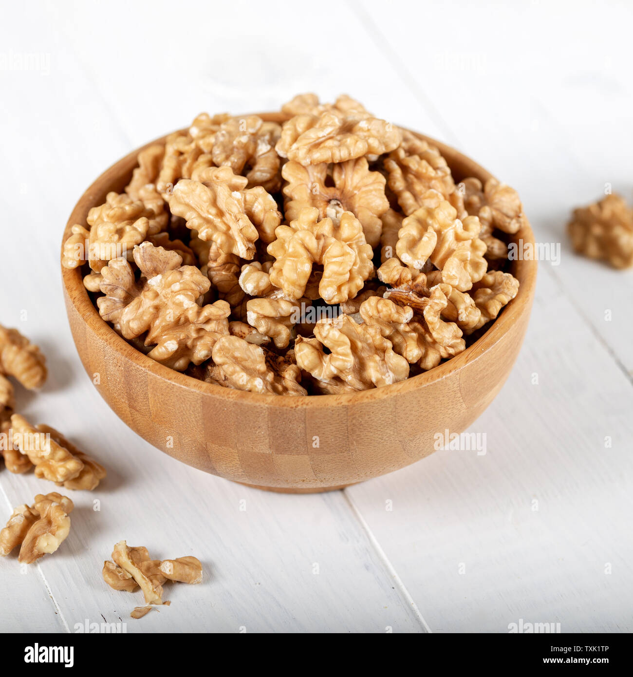 Walnut kernels in a wooden bowl on white background Stock Photo - Alamy
