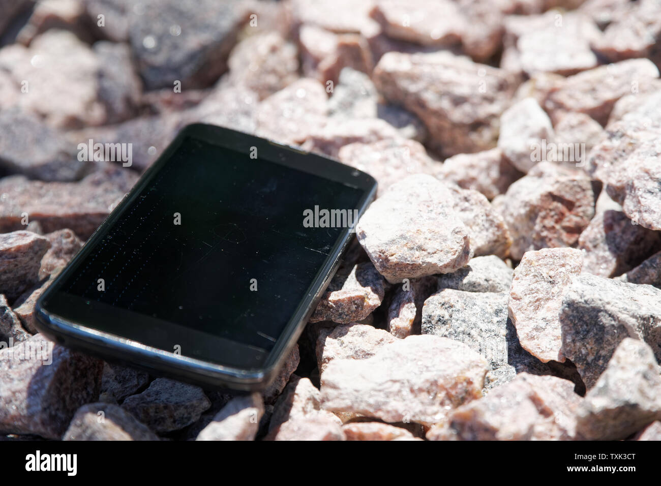 Broken cellphone abandoned and lost among the gravel Stock Photo - Alamy