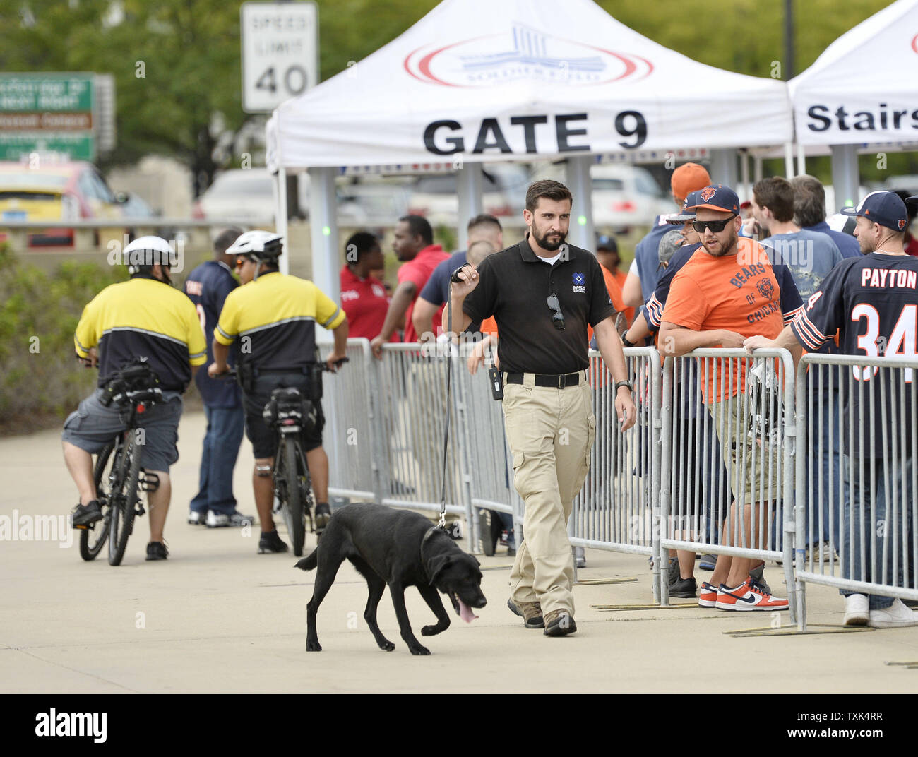 A security guard with a dog patrols outside of Soldier Field before the ...