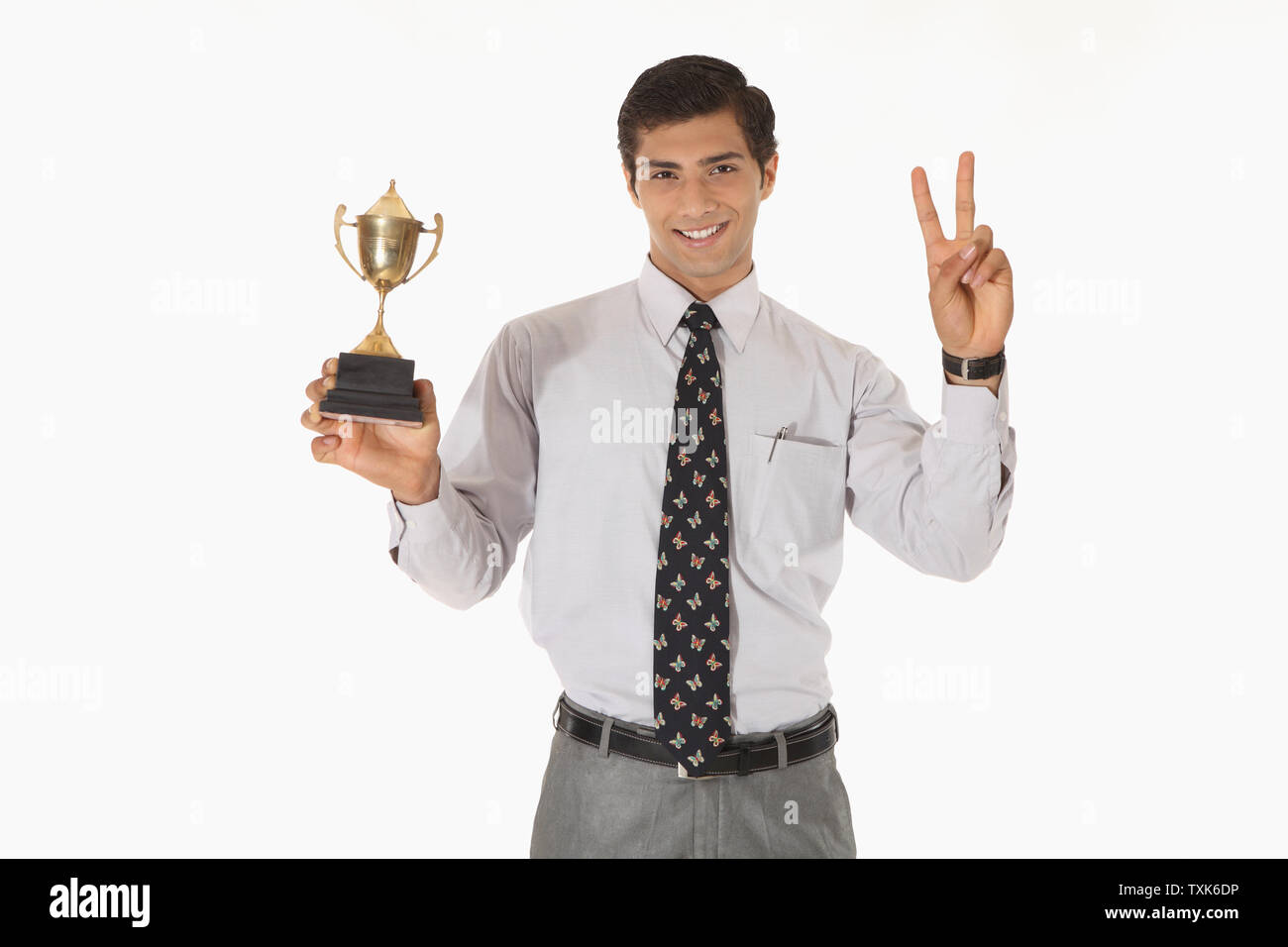Businessman showing trophy and smiling Stock Photo - Alamy