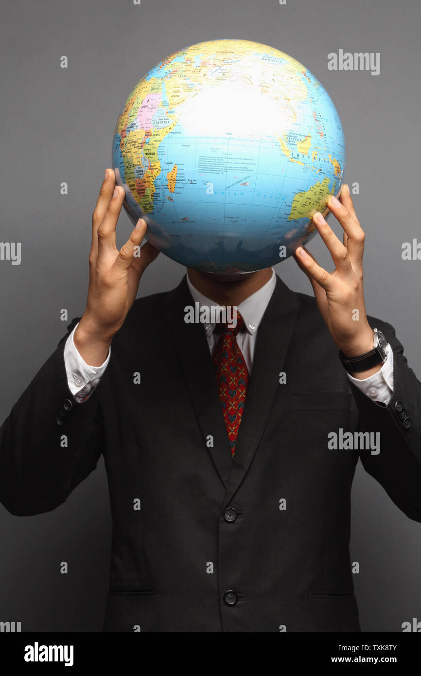 Businessman holding globe over face hi-res stock photography and images ...