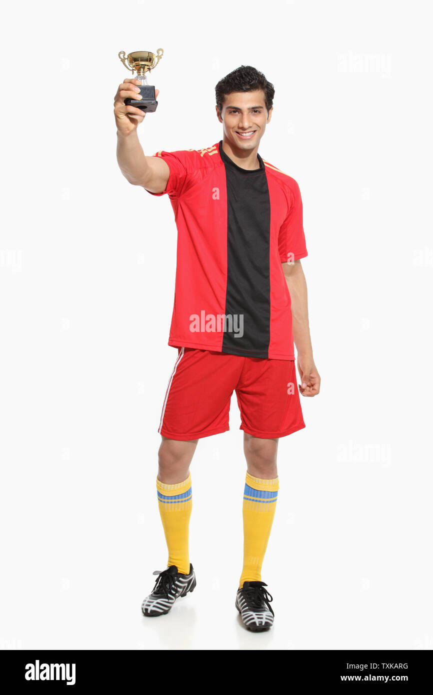 Portrait of a soccer player showing trophy Stock Photo - Alamy