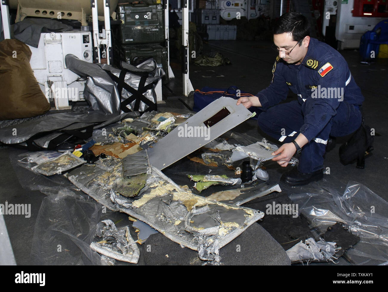 A Chilean military officer sorts through wreckage from Friday's ...