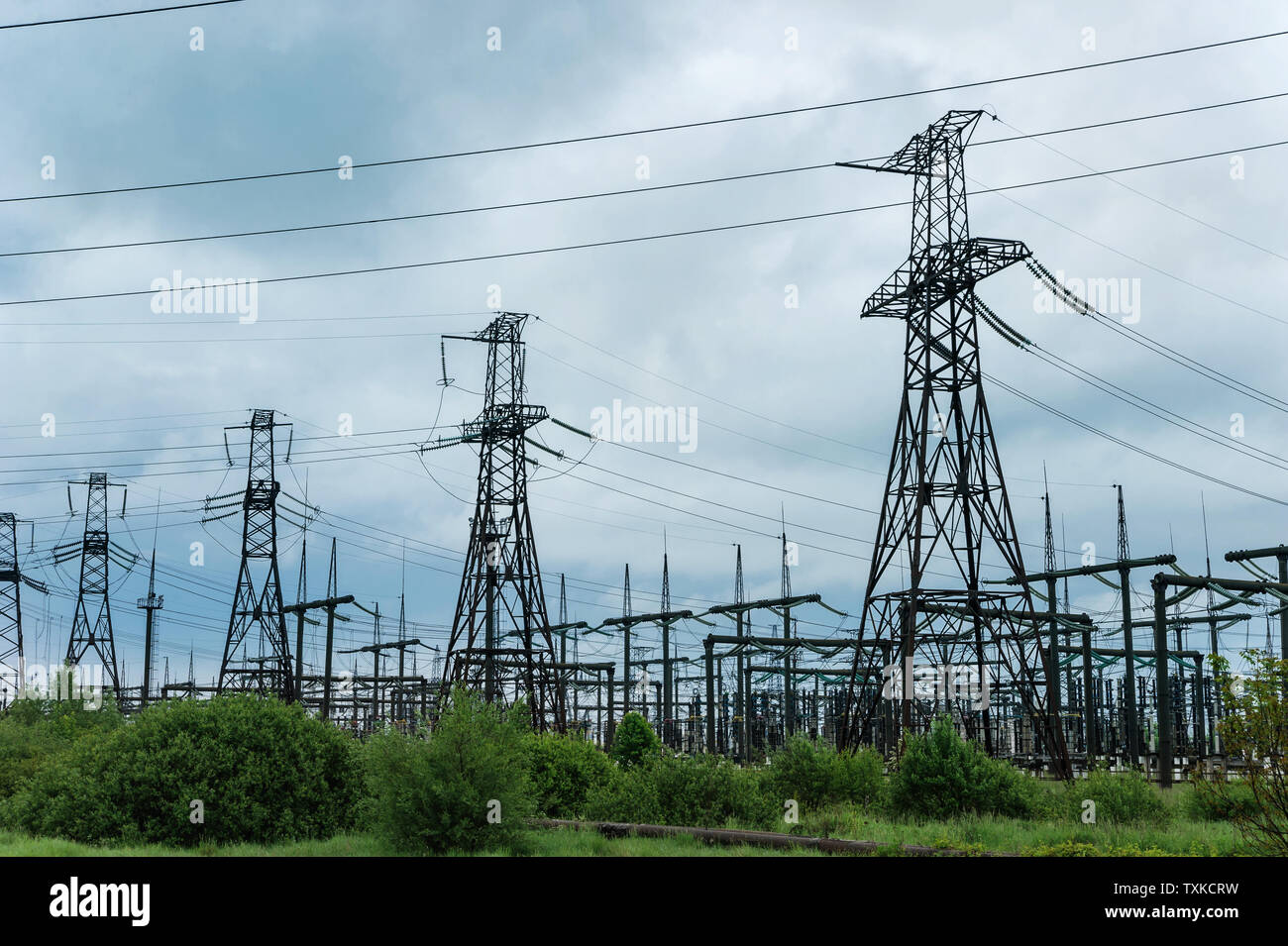 Transformer substation and high voltage tower on a background of clouds ...