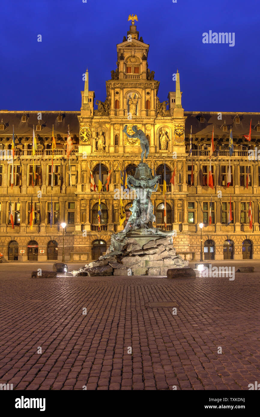 Night scene of Antwerp City Hall and Brabo's statue holding the giant's ...