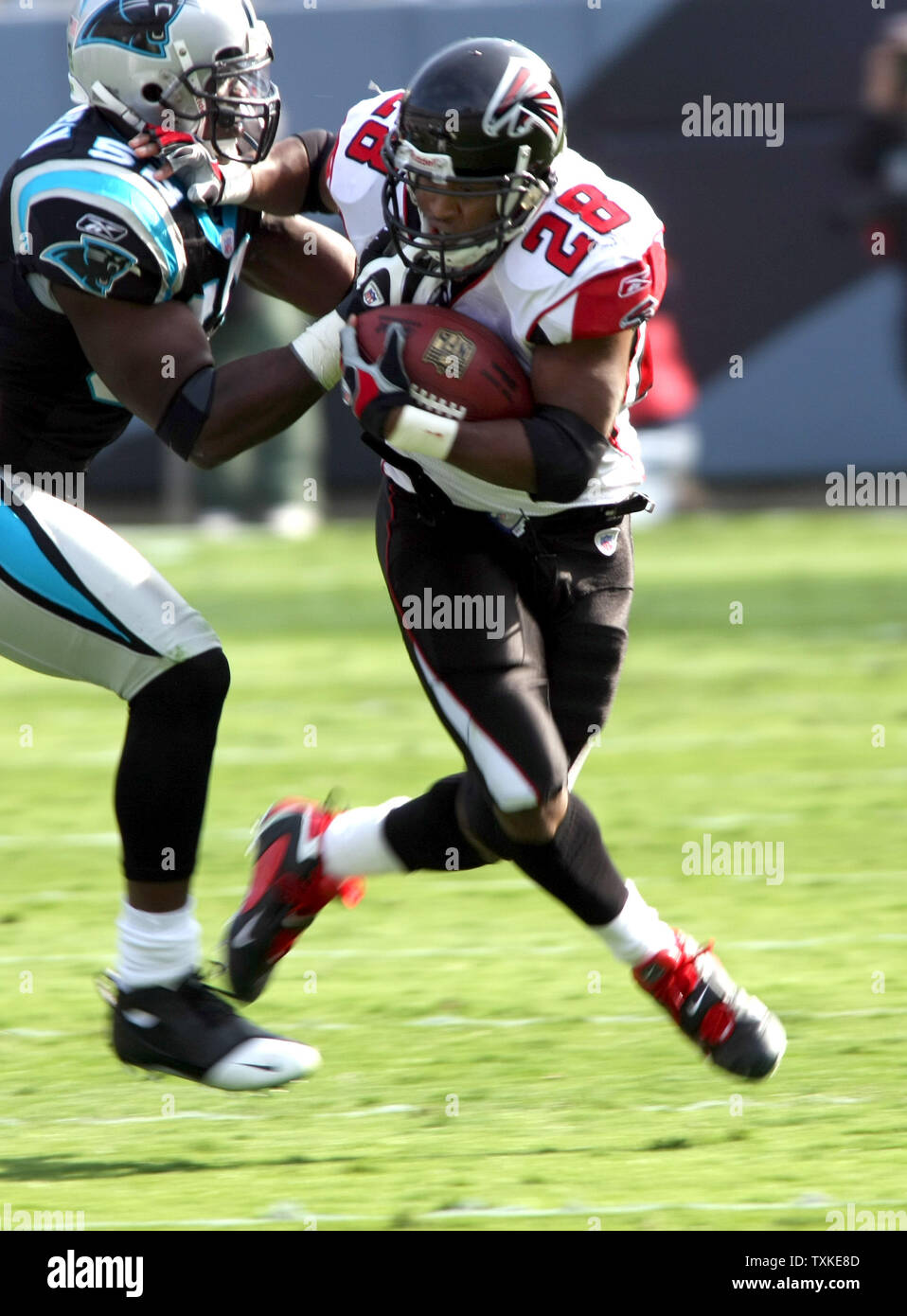 Atlanta Falcons running back Warrick Dunn, right, fights for yards as ...