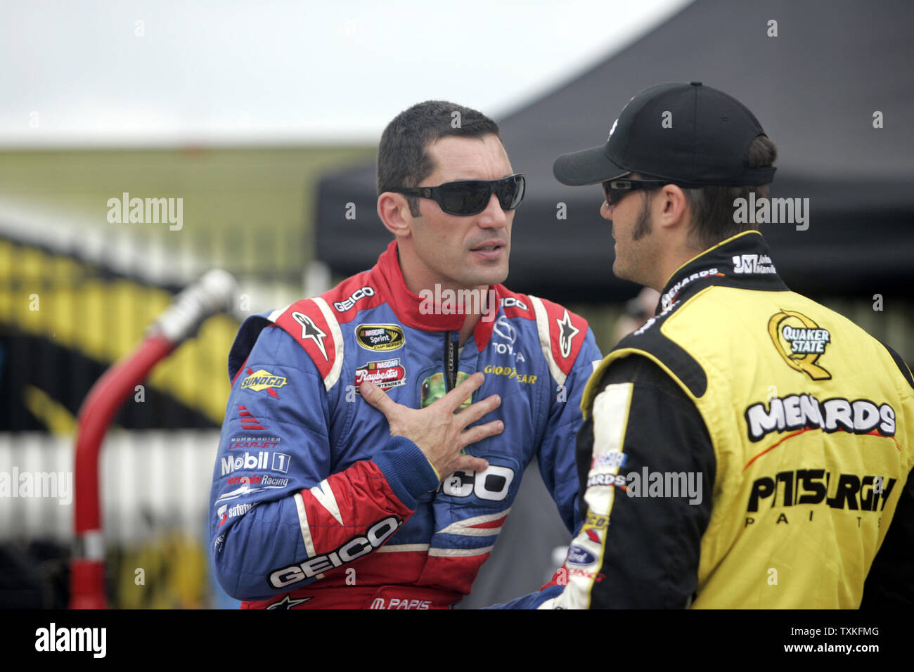 Race car drivers Max Papis, left, and Paul Menard talk on pit road ...