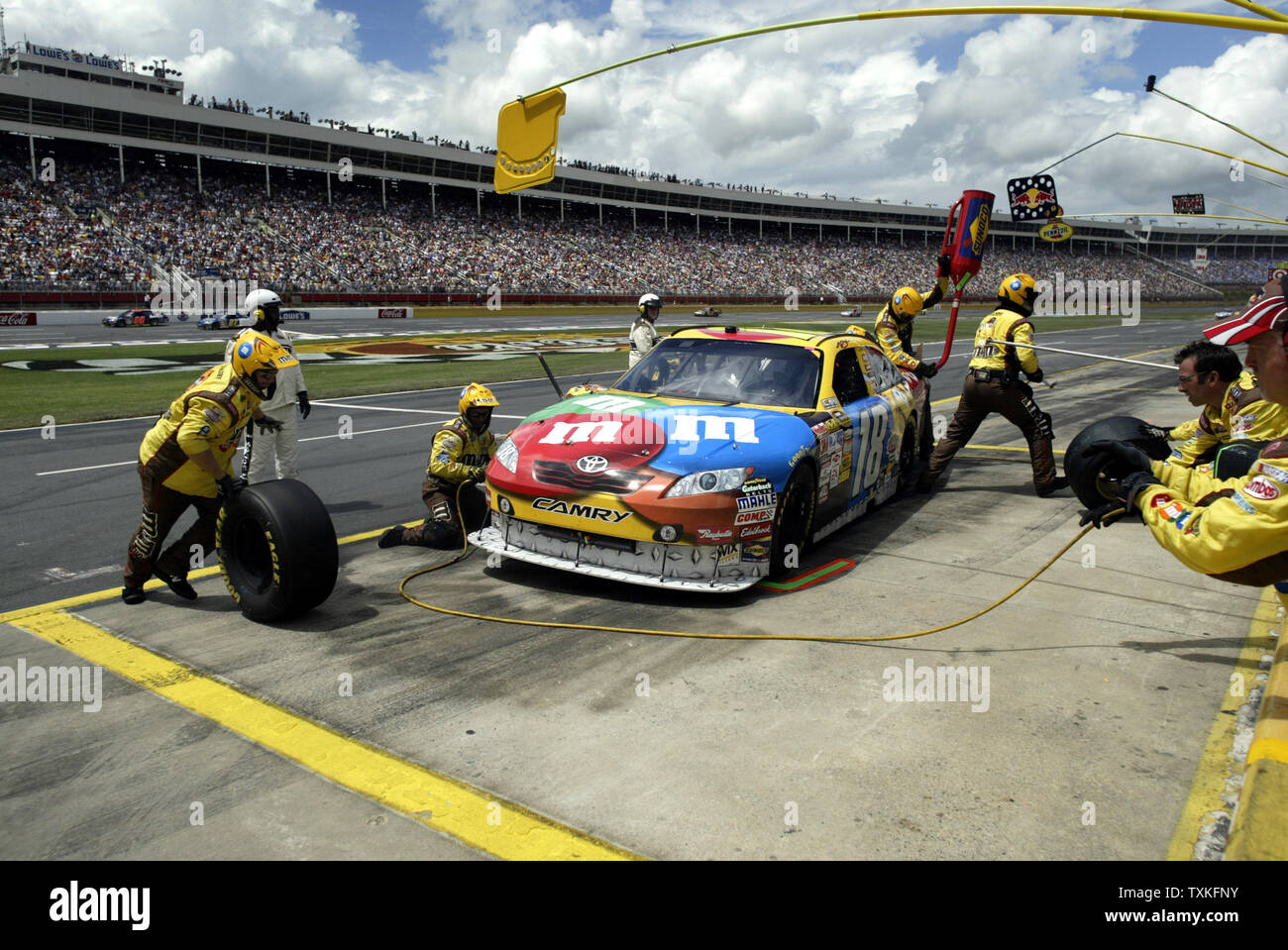 The M&M's Toyota pit crew rushes through a pit stop by driver Kyle ...