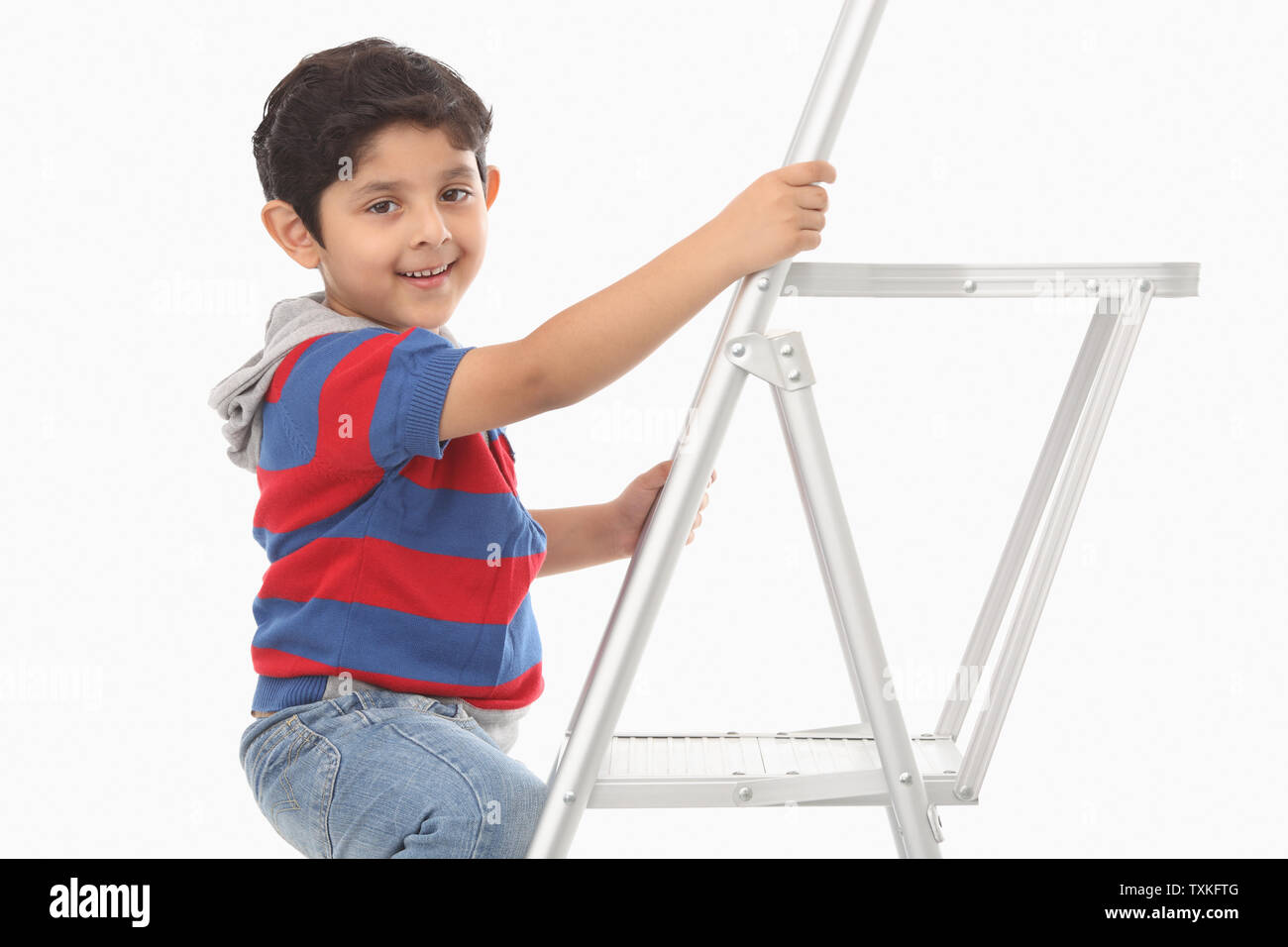 Boy climbing a step ladder and smiling Stock Photo - Alamy