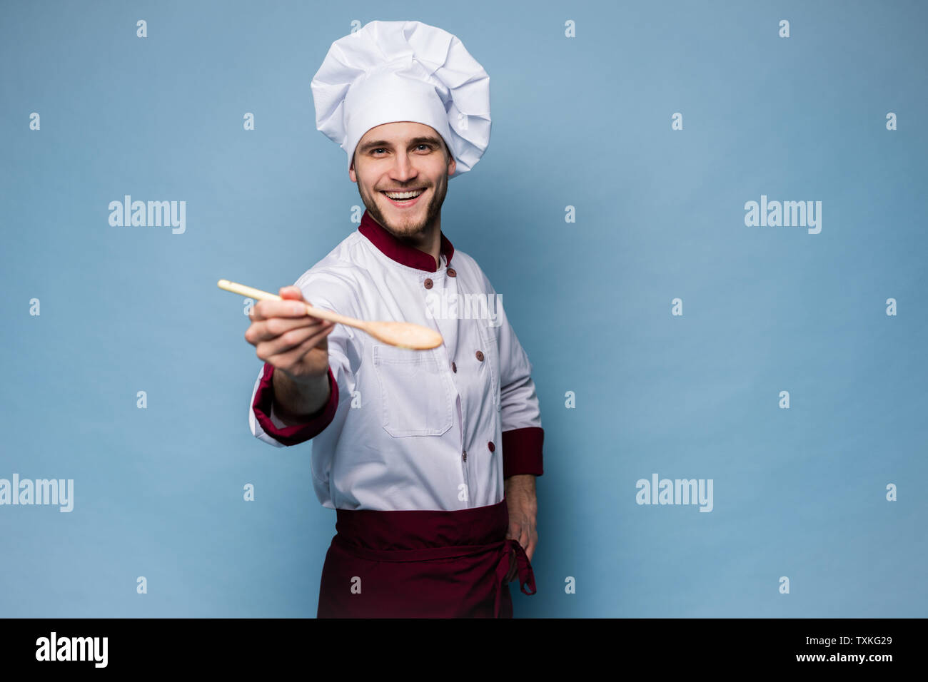 Chef trying meal. Positive professional chef in white uniform trying ...