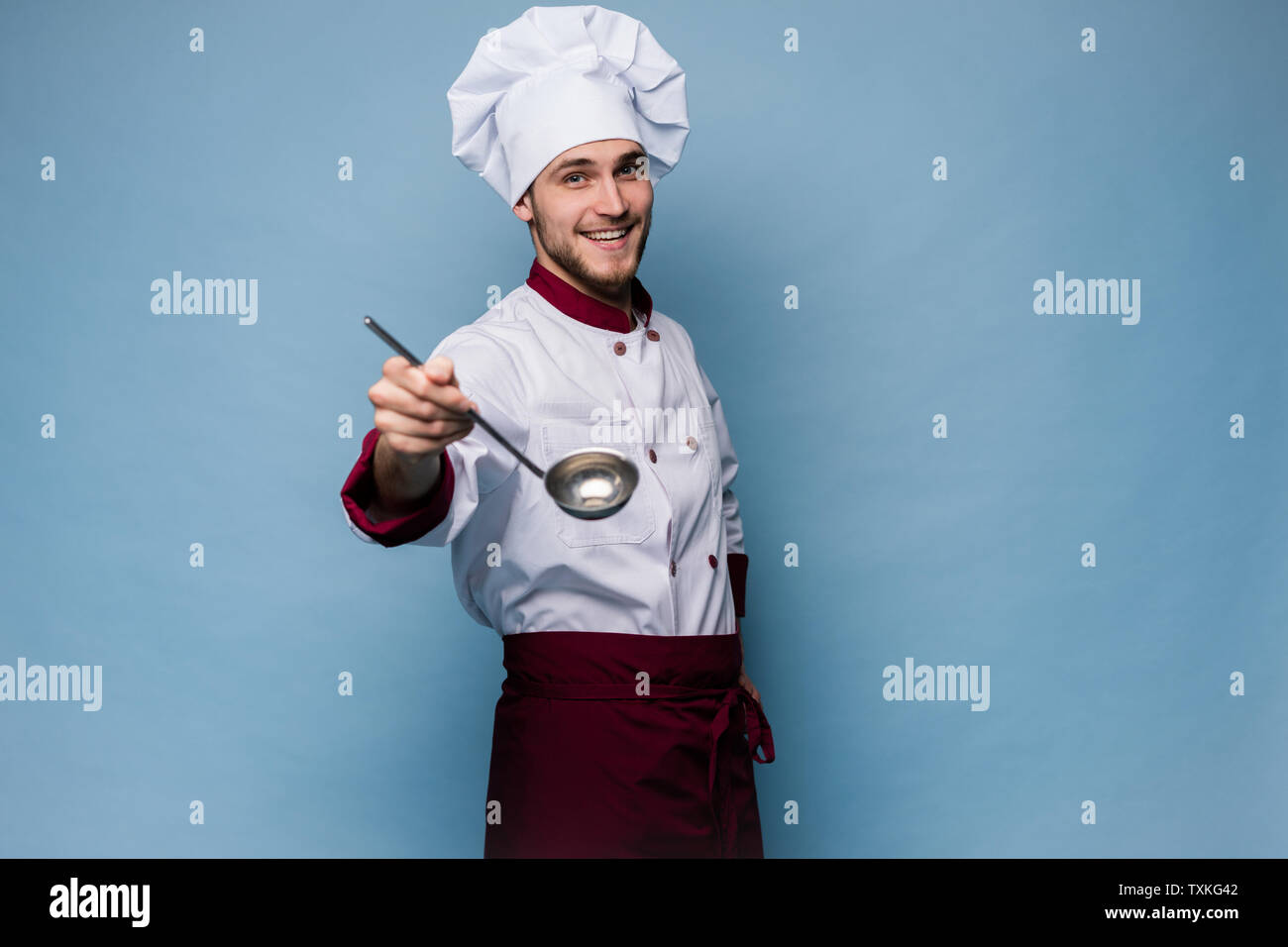 Chef trying meal. Positive professional chef in white uniform trying ...